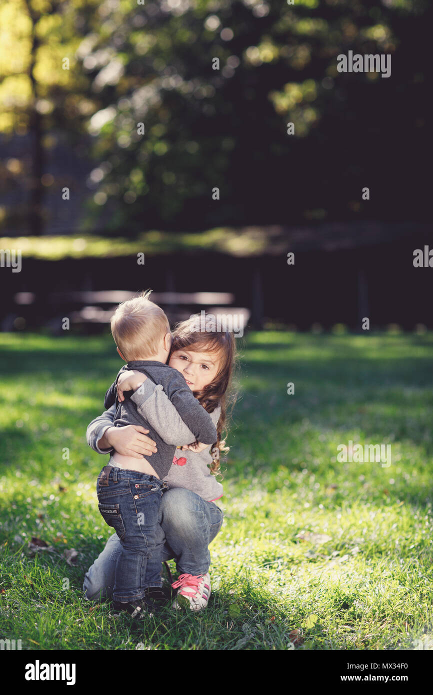 Happy children playing on green grass in spring park Stock Photo - Alamy