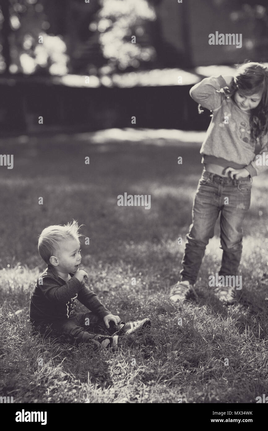 Happy children playing on green grass in spring park Stock Photo - Alamy