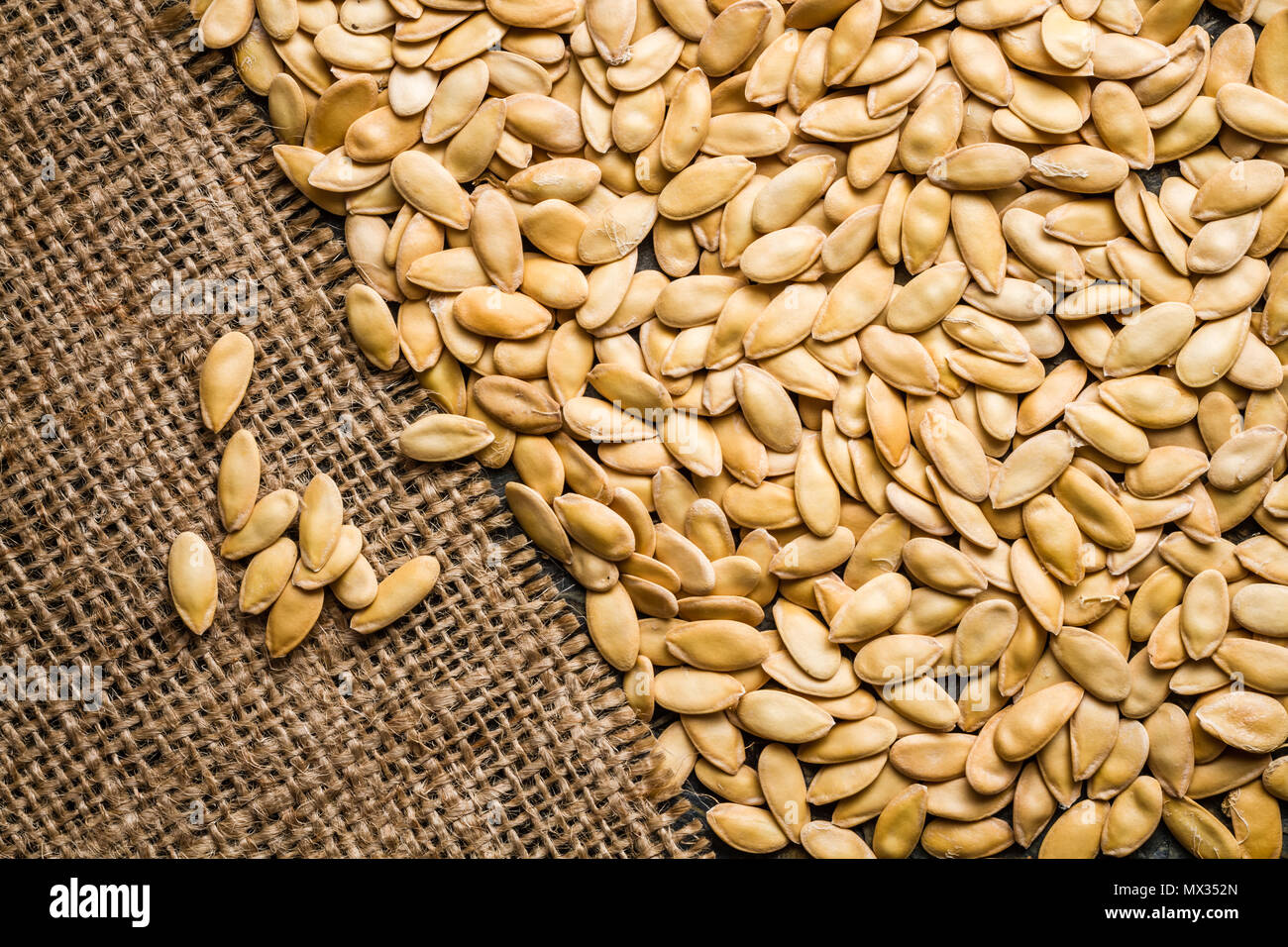 Melon seeds on sack cloth and table background Stock Photo - Alamy