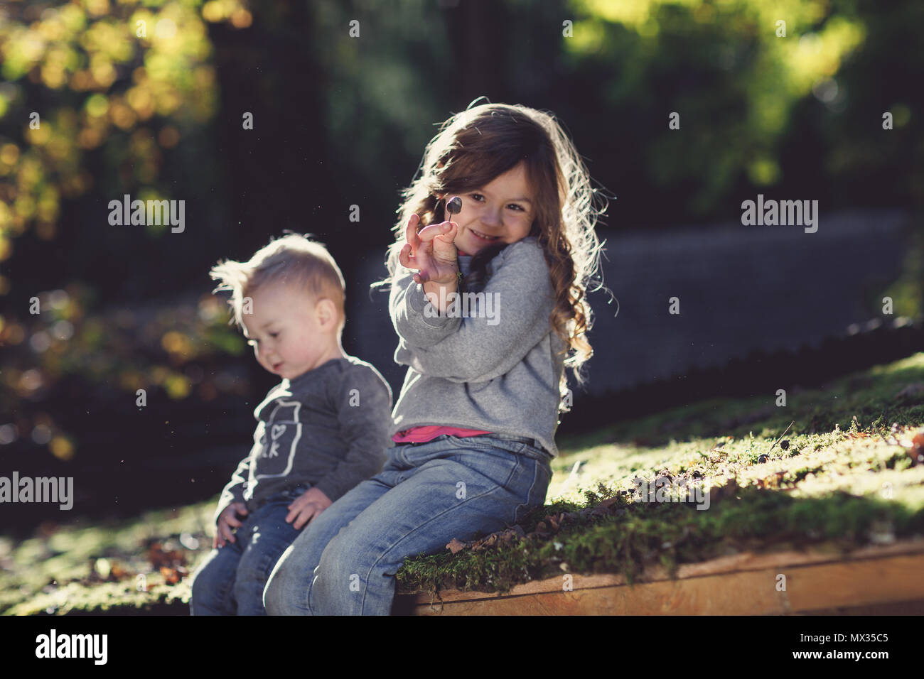 Happy children playing on green grass in spring park Stock Photo - Alamy