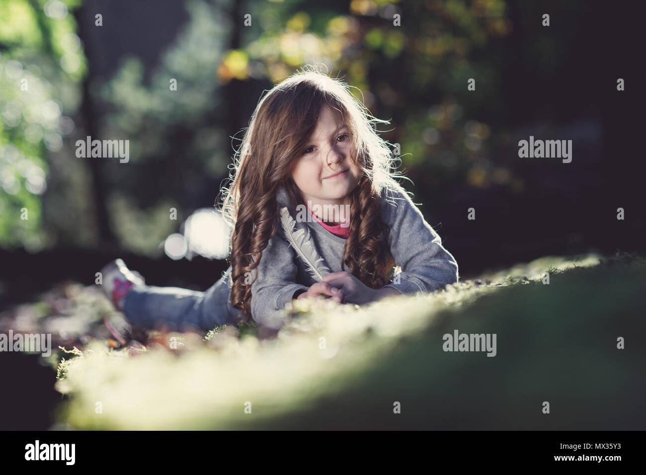 Happy children playing on green grass in spring park Stock Photo - Alamy
