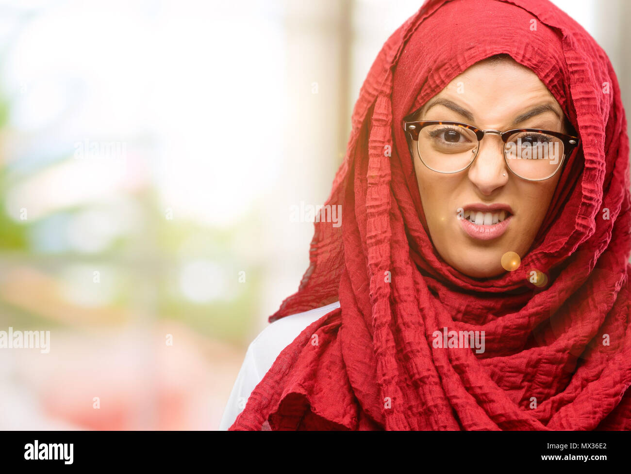 Young arab woman wearing hijab angry and stressful frowns face in ...
