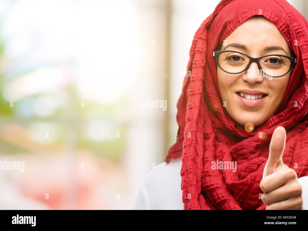 Young arab woman wearing hijab smiling broadly showing thumbs up ...
