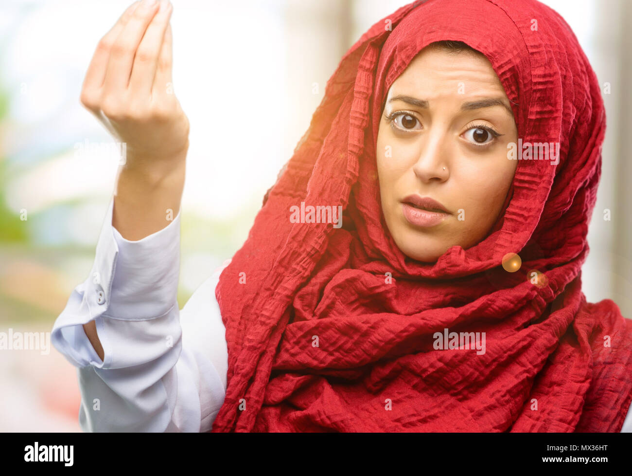 Young arab woman wearing hijab angry gesturing typical italian gesture ...