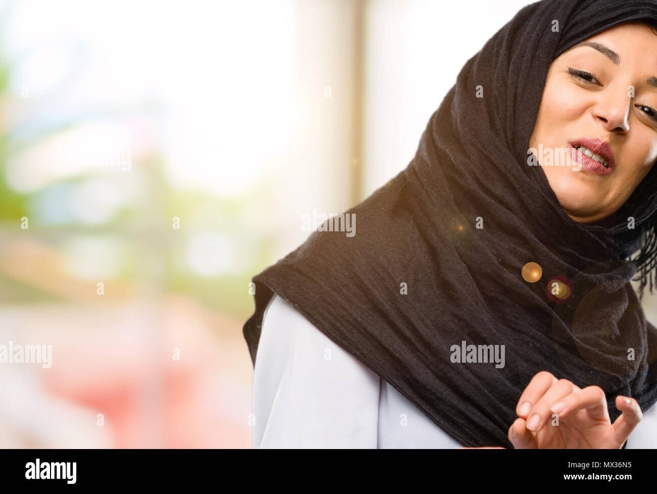 Young arab woman wearing hijab disgusted and angry, keeping hands in ...