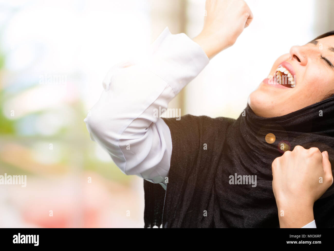 Young arab woman wearing hijab happy and excited celebrating victory ...