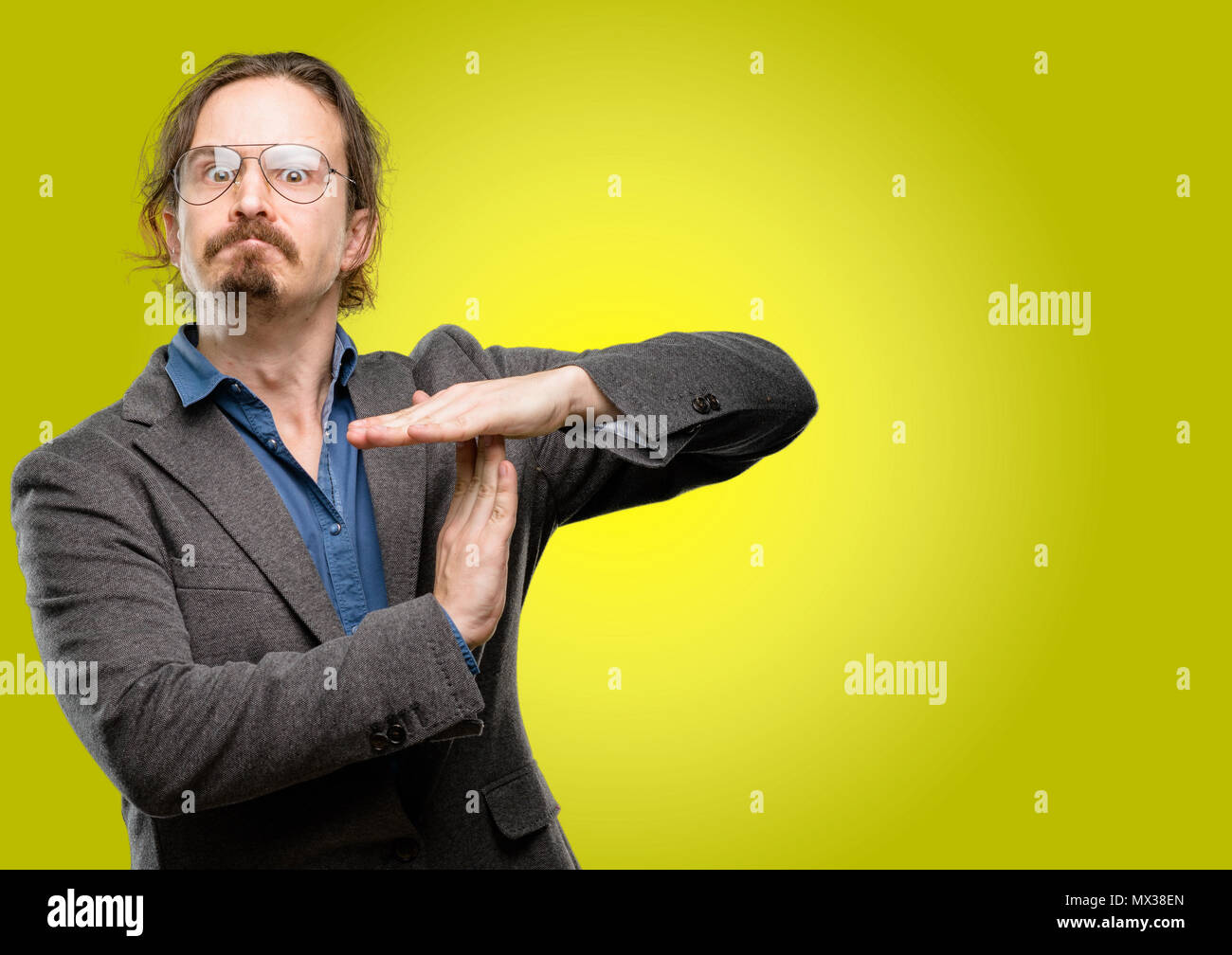Handsome young man serious making a time out gesture with hands Stock ...