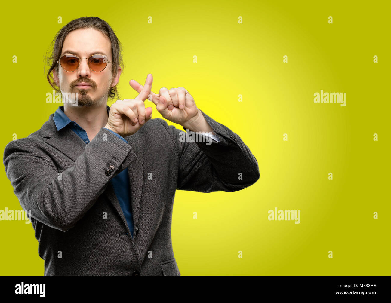 Handsome young man annoyed with bad attitude making stop sign with hand ...