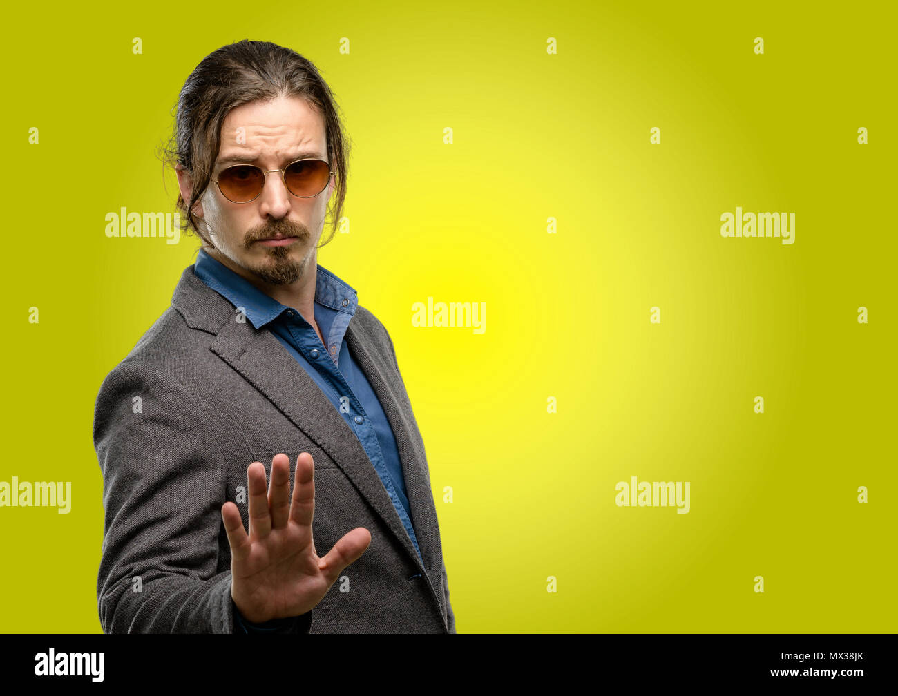 Handsome young man annoyed with bad attitude making stop sign with hand ...