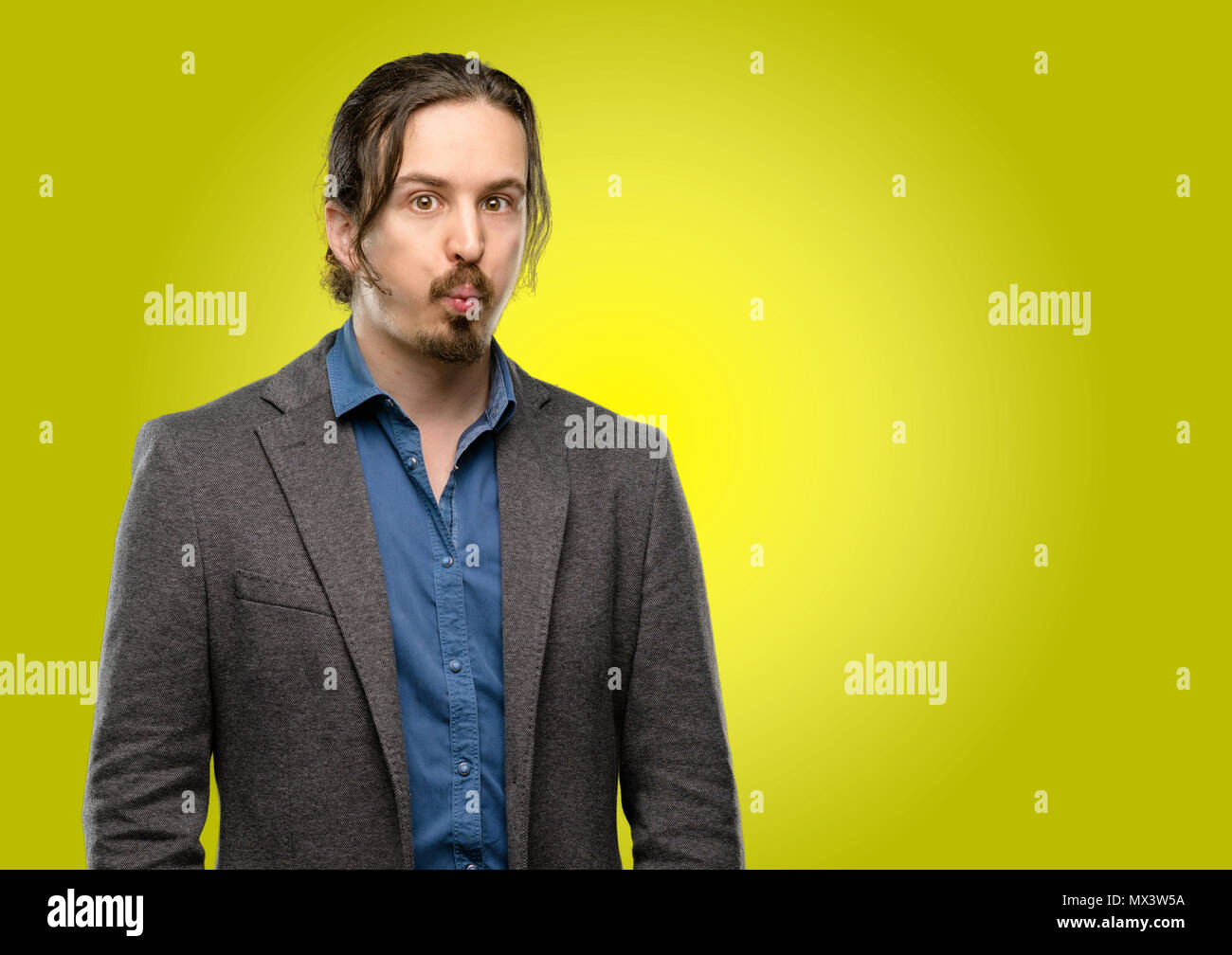 Handsome young man puffing out cheeks, having fun making funny face ...