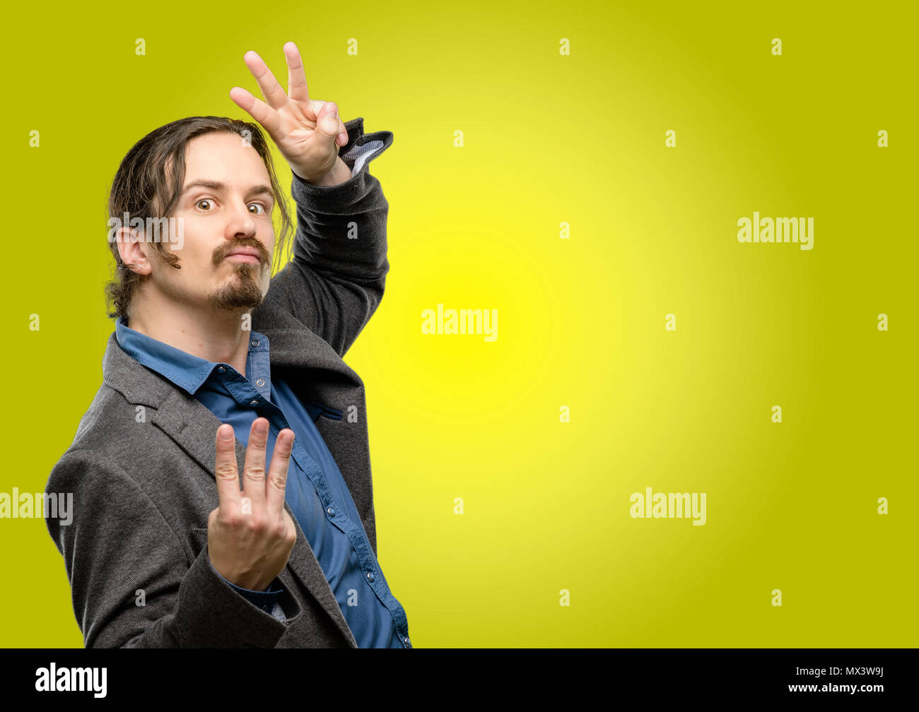 Handsome young man raising his finger, is the number three Stock Photo ...