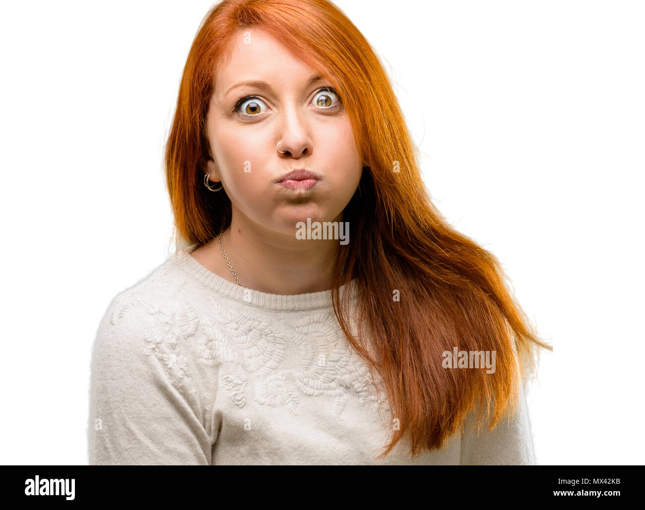 Beautiful young redhead woman puffing out cheeks, having fun making ...