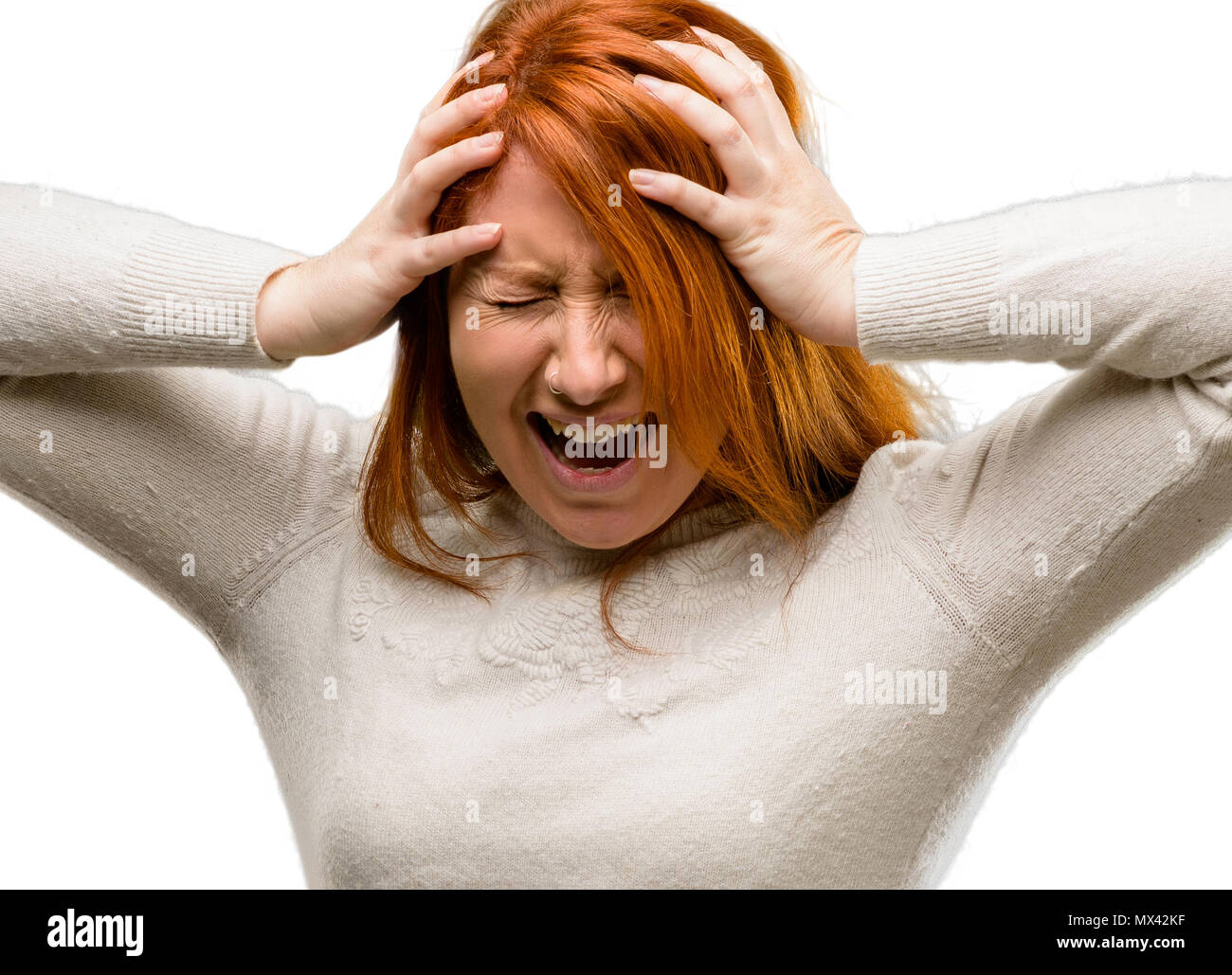 Beautiful young redhead woman stressful keeping hands on head ...