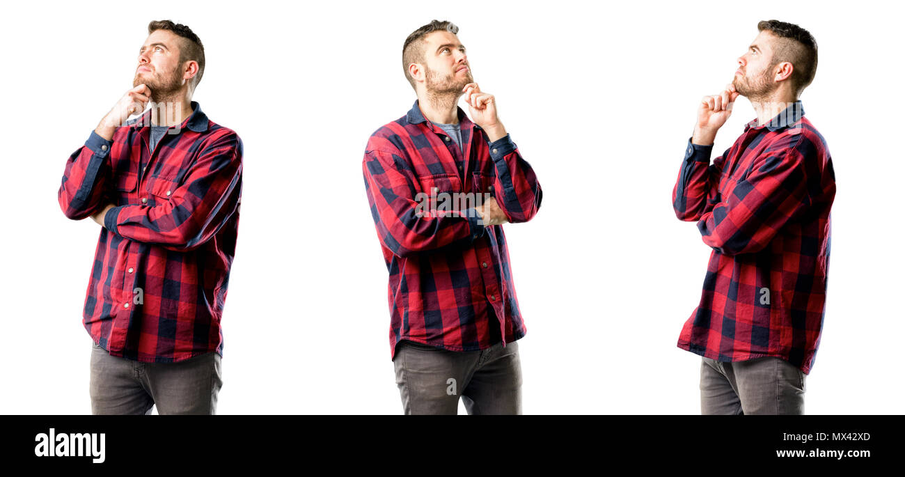 Young man thinking and looking up expressing doubt and wonder isolated ...