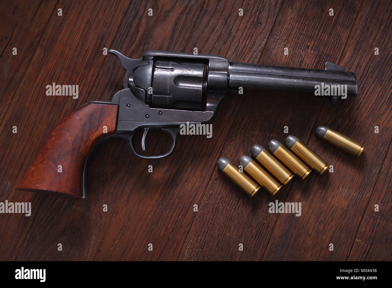 Old western revolver with cartridges on wooden table Stock Photo - Alamy