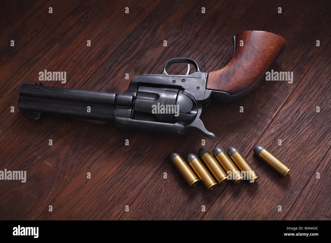 Old western revolver with cartridges on wooden table Stock Photo - Alamy