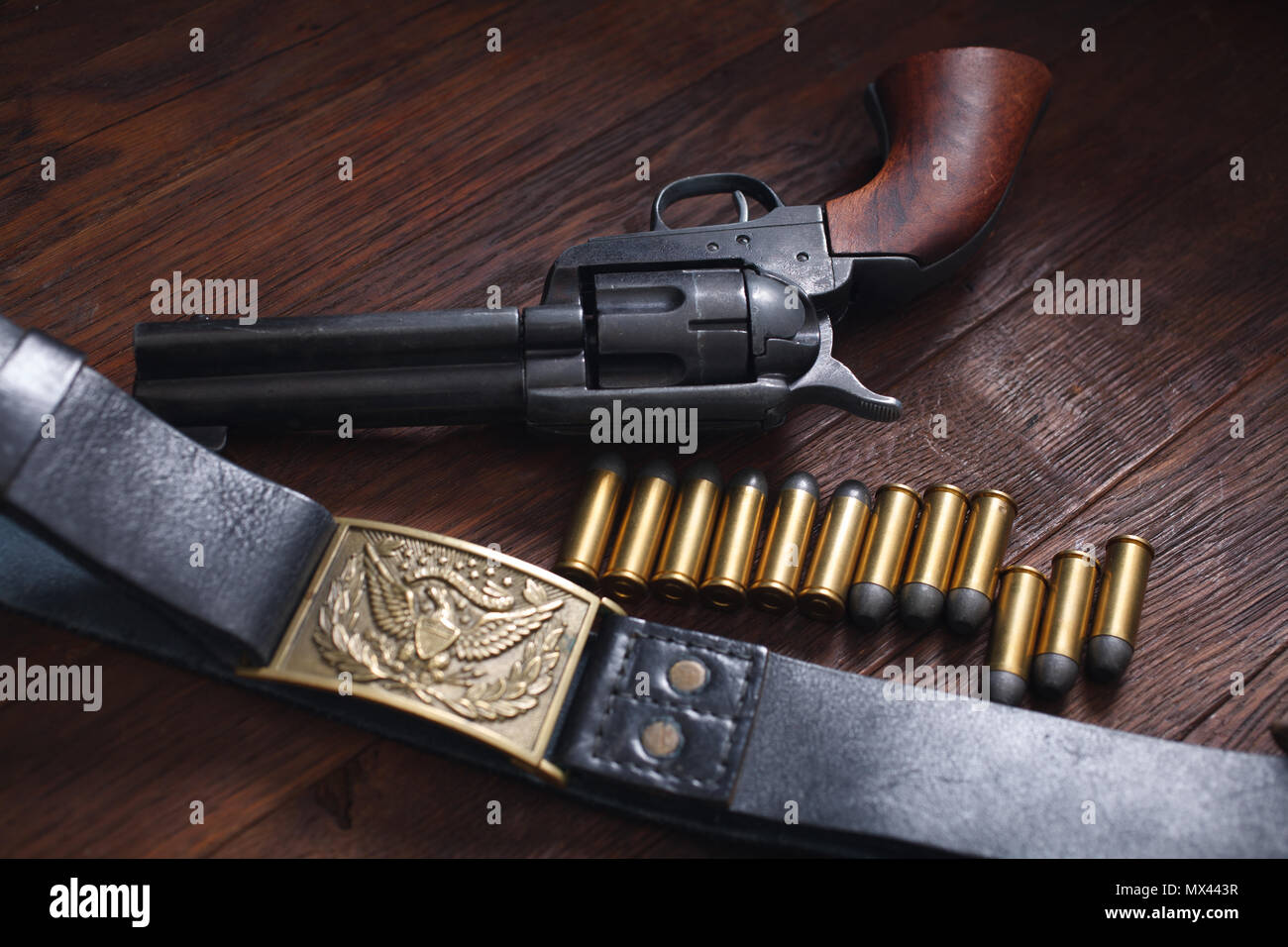Old western revolver with cartridges on wooden table Stock Photo - Alamy