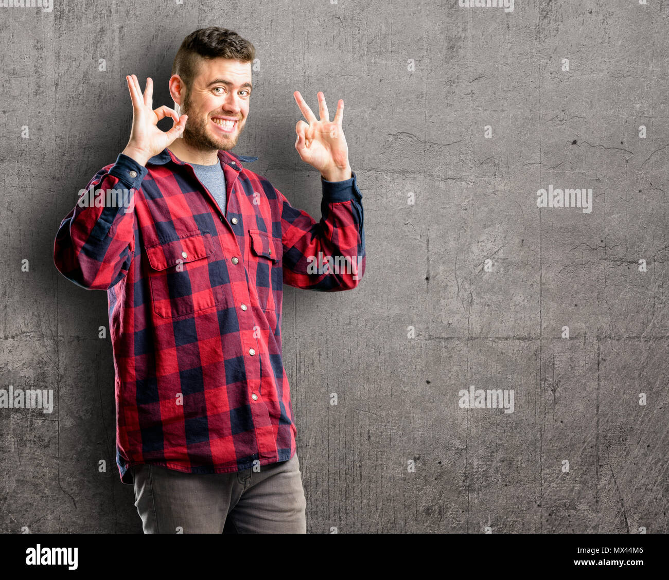 Young handsome man doing ok sign gesture with both hands expressing ...