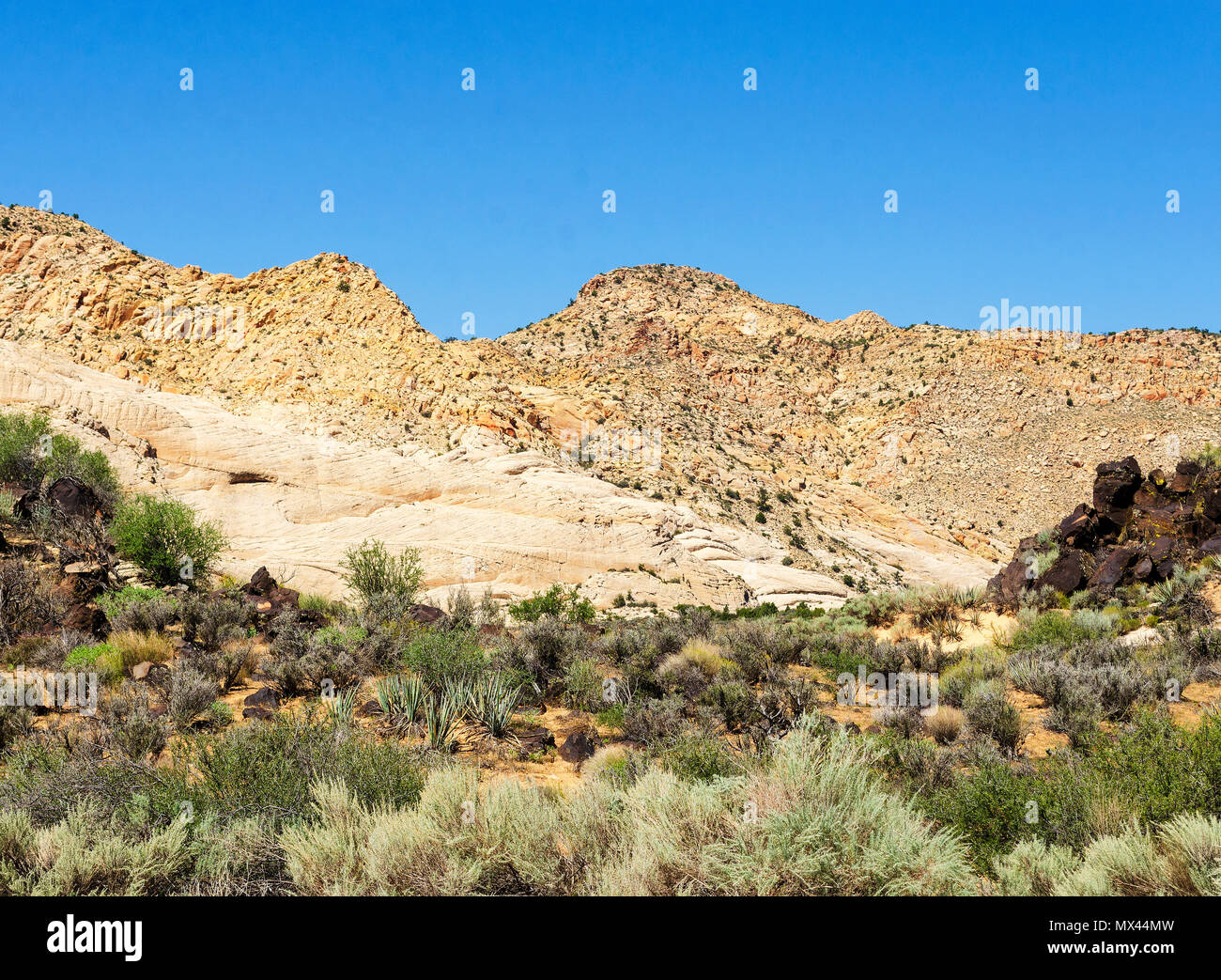 White rock covered mountains with steep cliffs under bright blue sky ...
