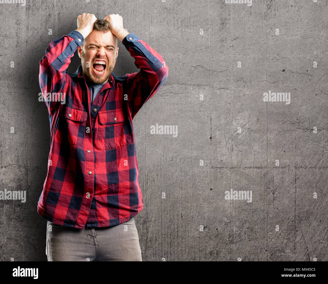 Young handsome man stressful keeping hands on head, terrified in panic ...