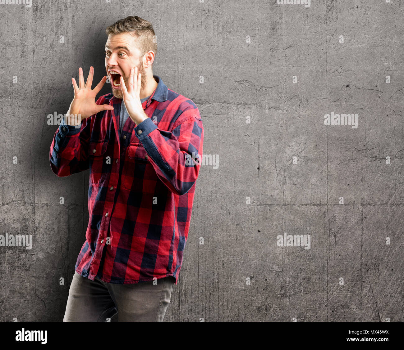 Young handsome man stressful keeping hands on head, terrified in panic ...