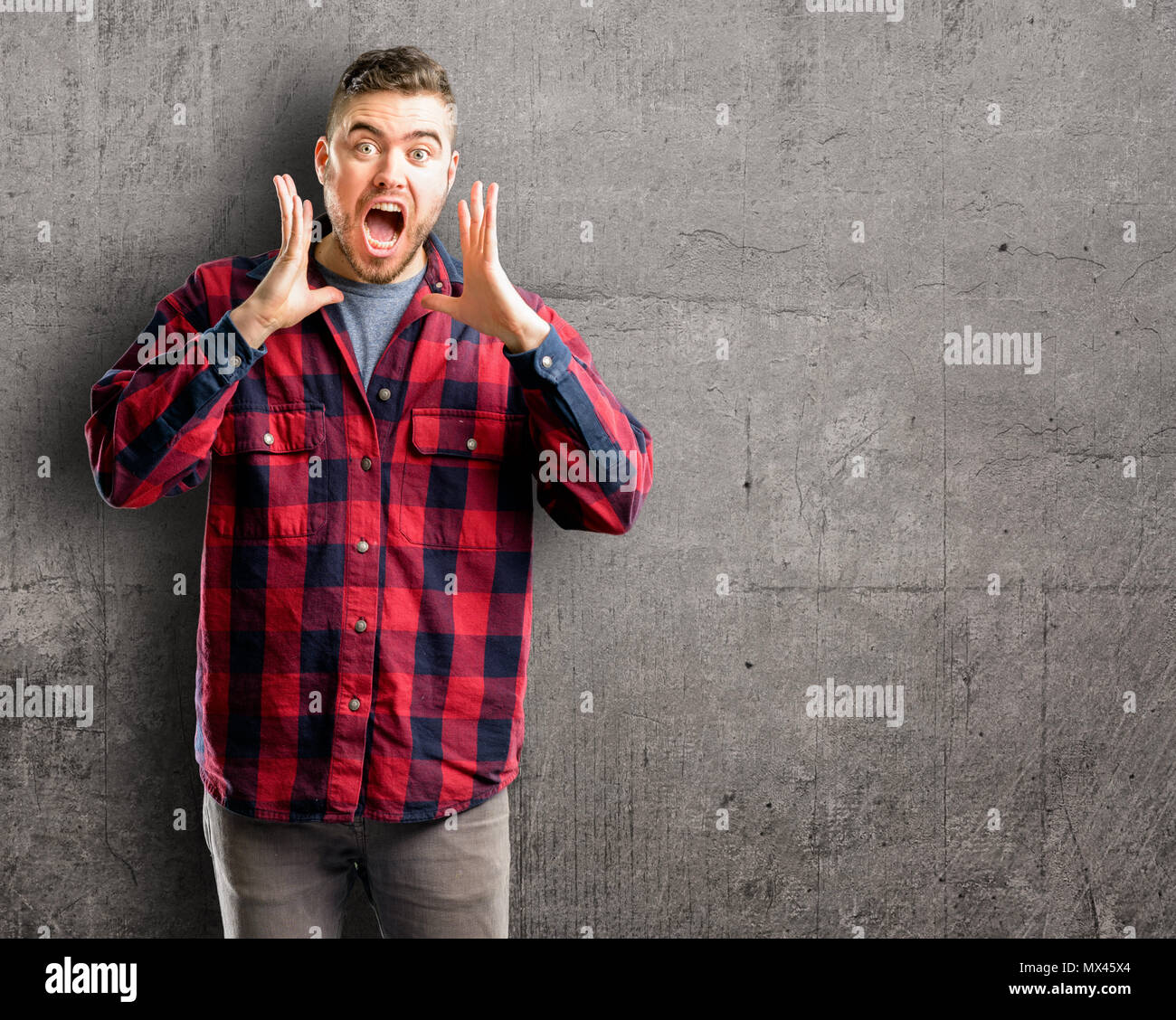 Young handsome man stressful keeping hands on head, terrified in panic ...