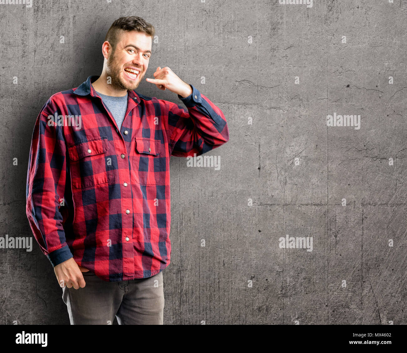 Young handsome man happy and excited making showing call me gesture ...