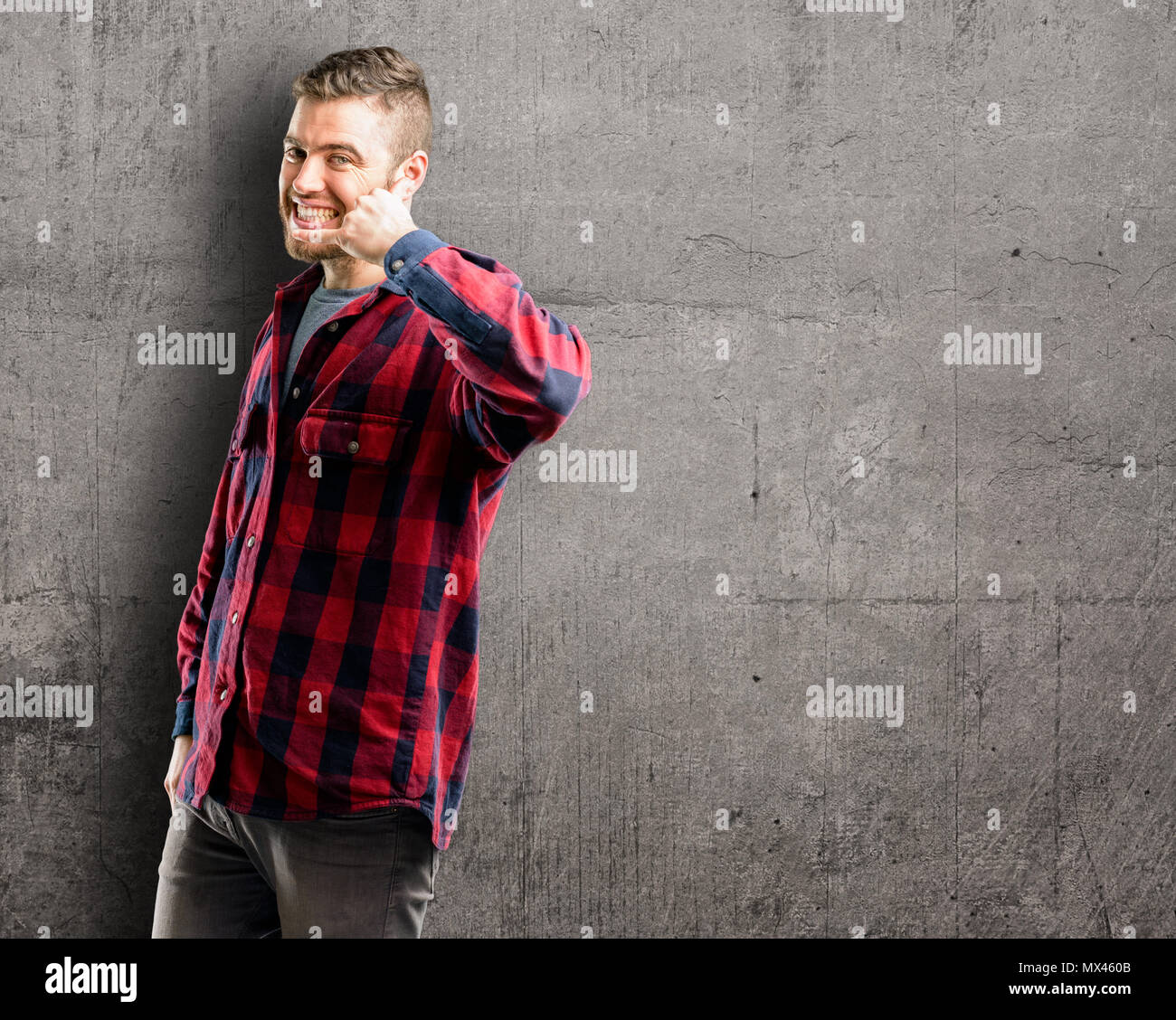 Young handsome man happy and excited making showing call me gesture ...