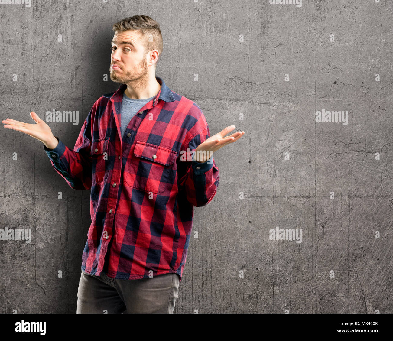 Young handsome man doubt expression, confuse and wonder concept ...