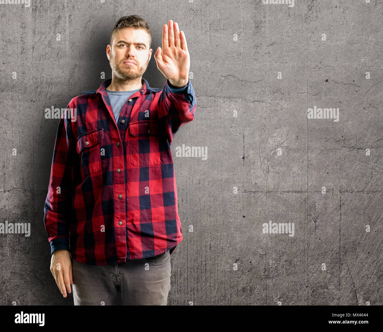 Young handsome man annoyed with bad attitude making stop sign with hand ...