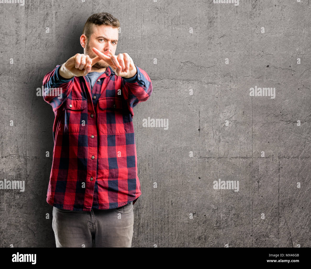 Young handsome man annoyed with bad attitude making stop sign with hand ...