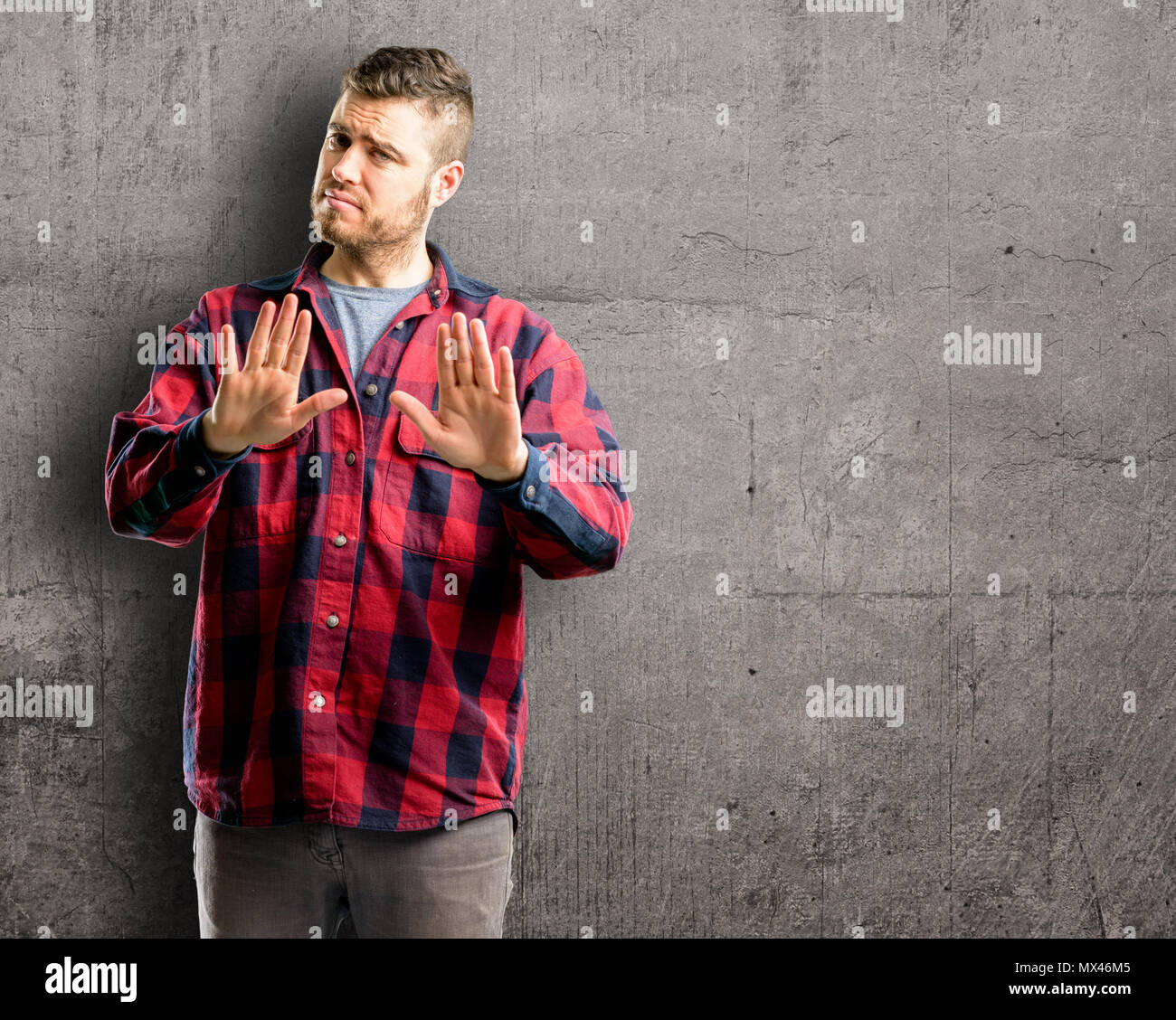 Young handsome man annoyed with bad attitude making stop sign with hand ...