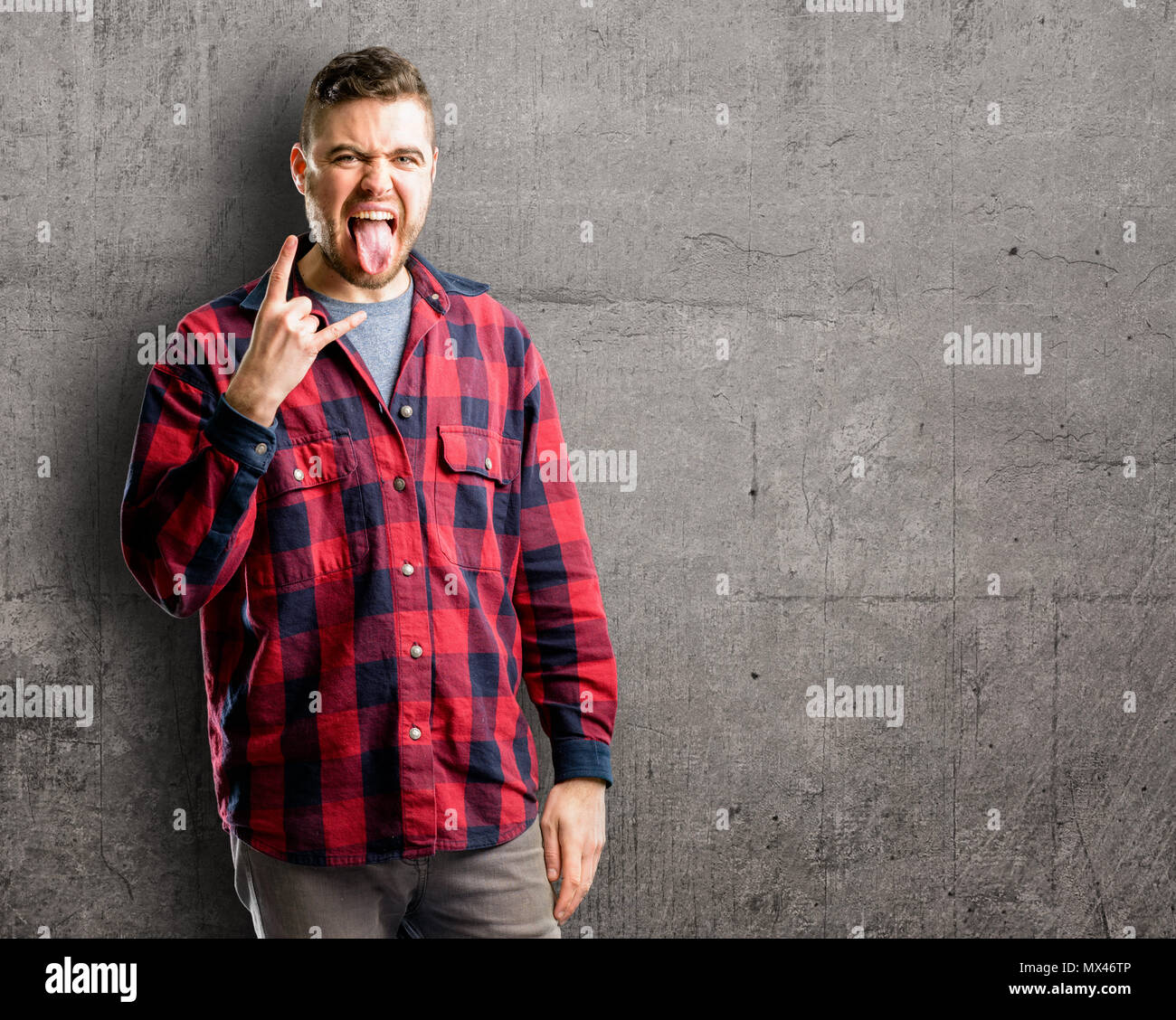 Young handsome man making rock symbol with hands, shouting and ...