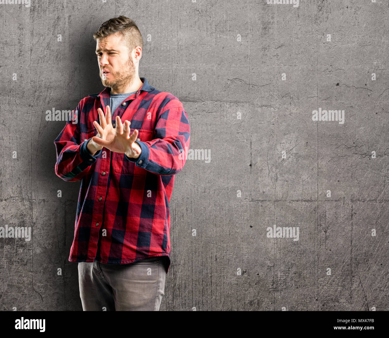 Young handsome man disgusted and angry, keeping hands in stop gesture ...