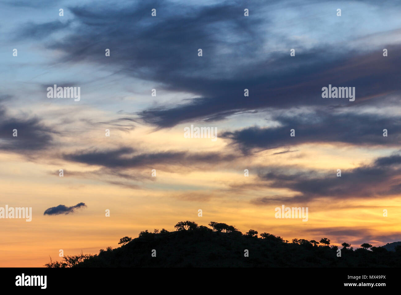 Dramatic multi-coloured sky above silhouetted hills in the Addo ...