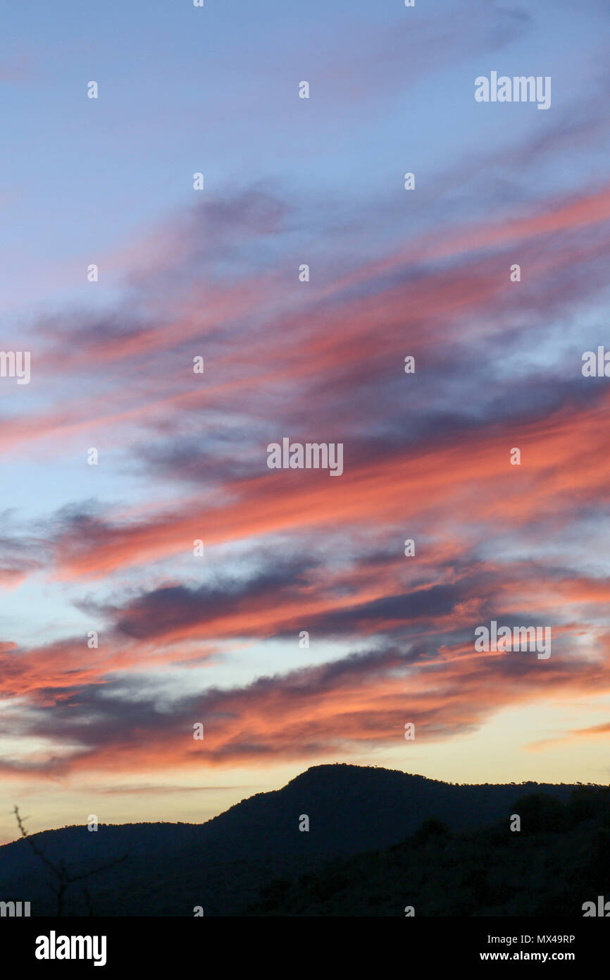 Dramatic multi-coloured sky above silhouetted hills in the Addo ...