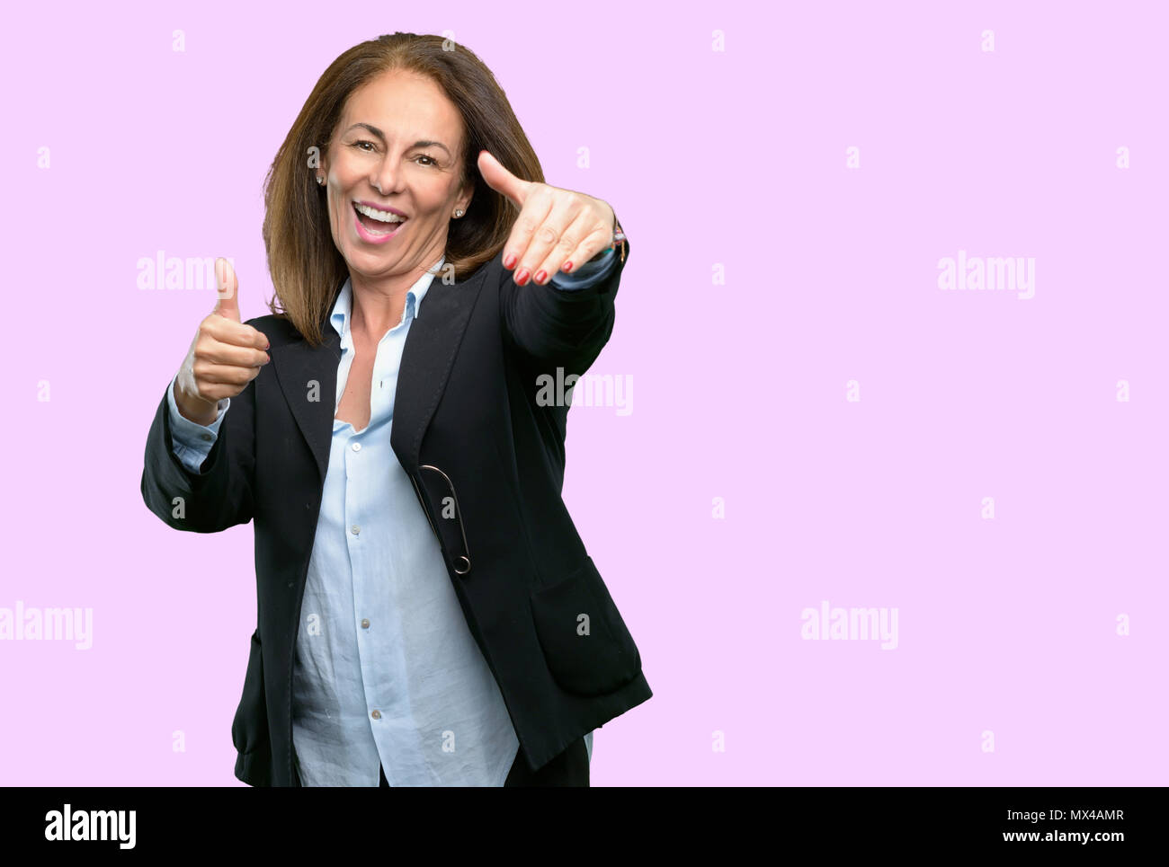 Middle age business woman stand happy and positive with thumbs up ...