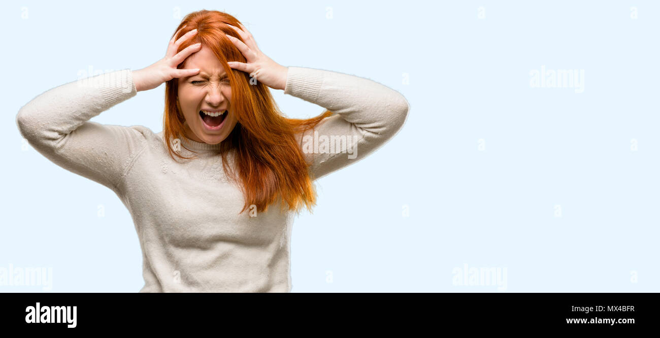 Beautiful young redhead woman stressful keeping hands on head ...