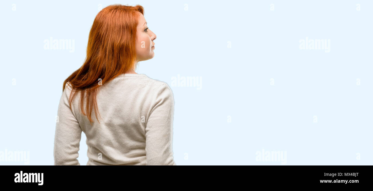 Beautiful young redhead woman backside, rear view isolated over blue ...