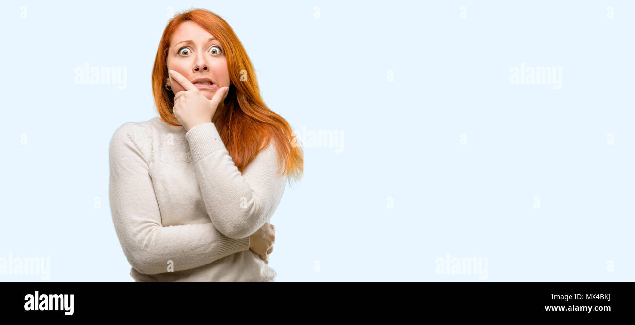 Beautiful young redhead woman scared in shock, expressing panic and ...
