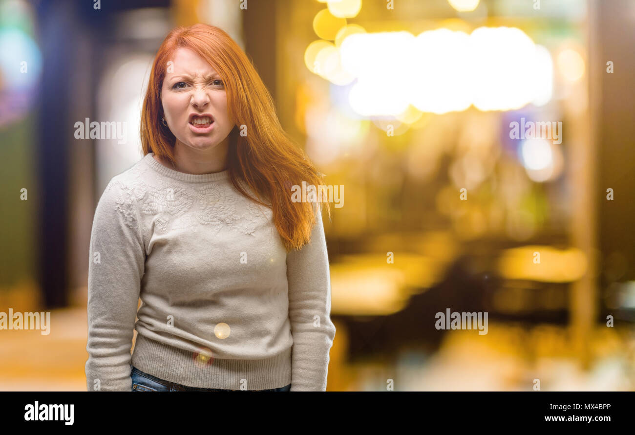 Beautiful young redhead woman angry and stressful frowns face in ...