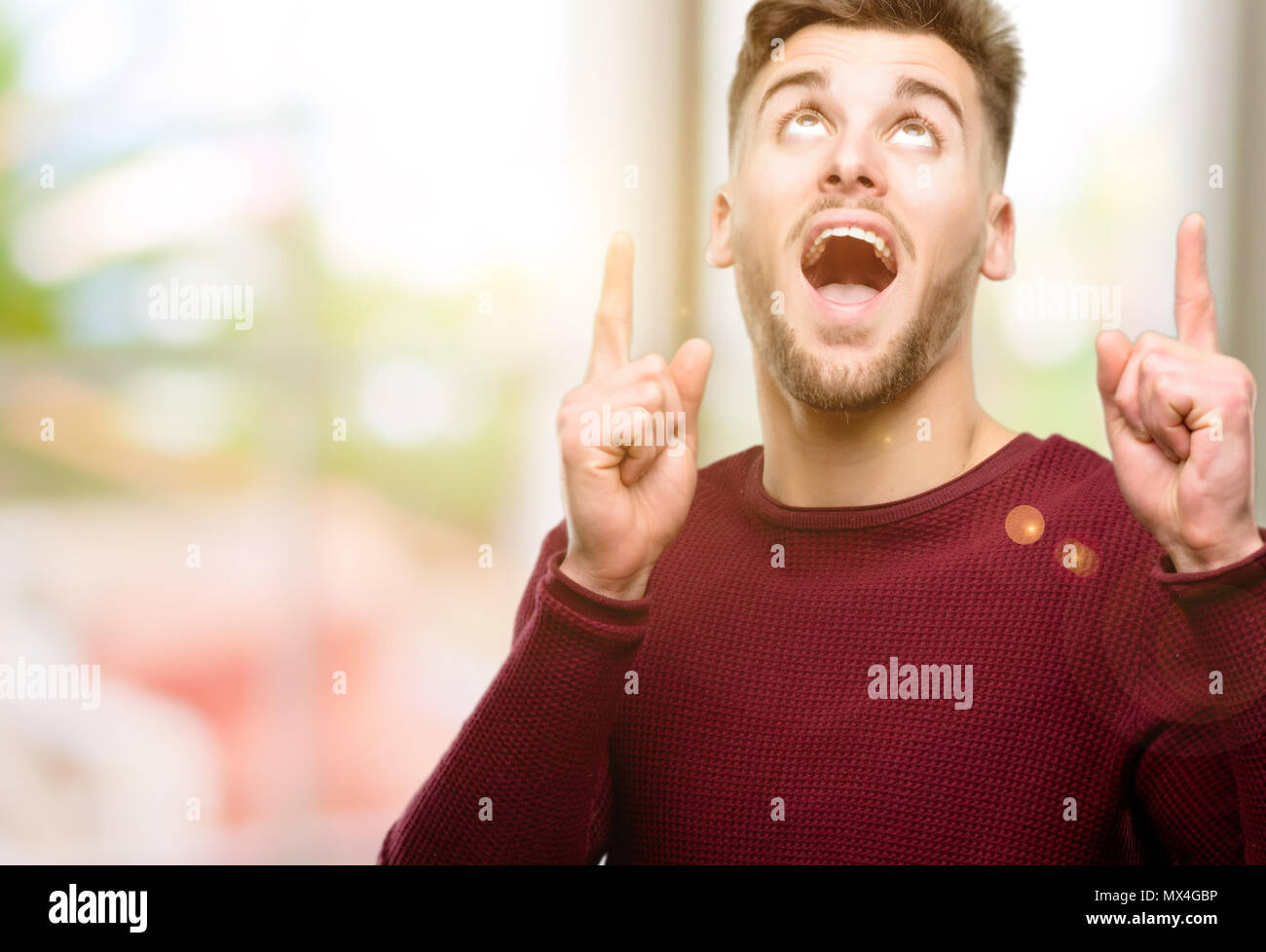 Handsome young man happy and surprised cheering expressing wow gesture ...