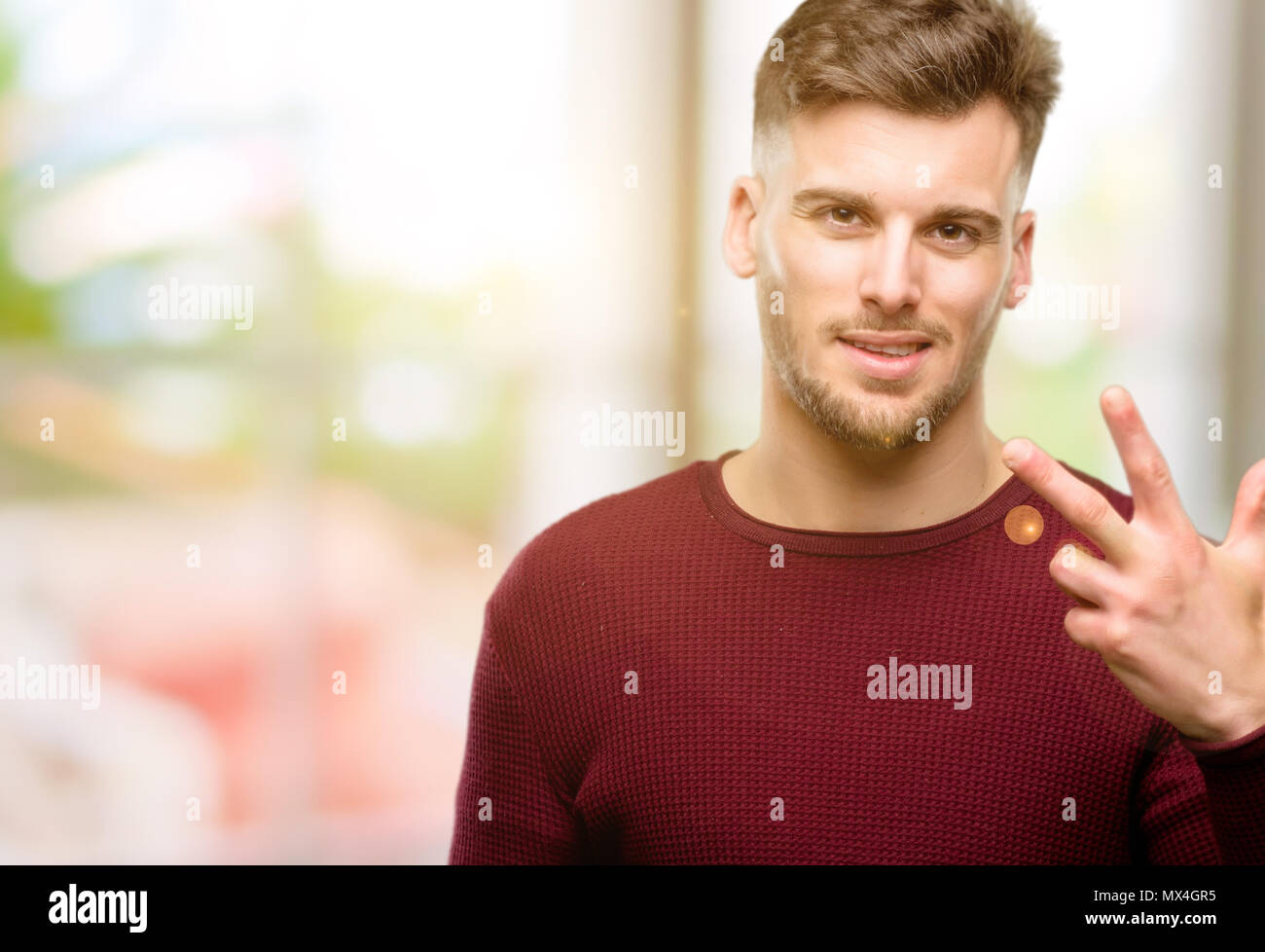 Handsome young man raising his finger, is the number three Stock Photo ...