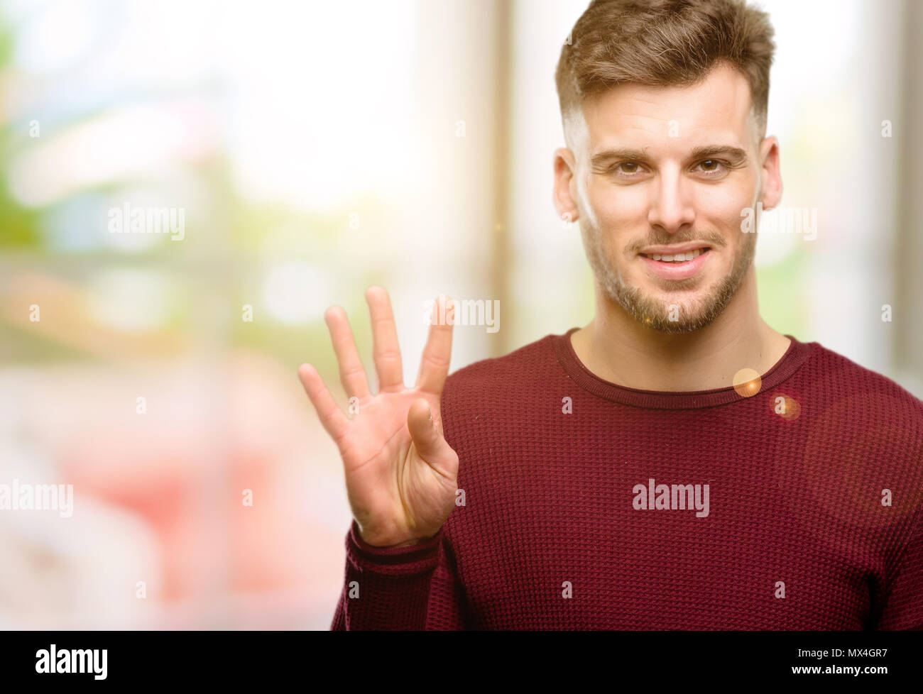 Handsome young man raising his finger, is the number four Stock Photo ...