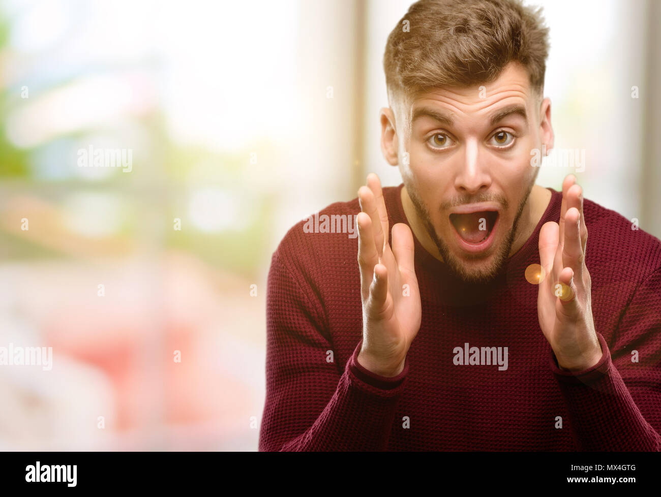 Handsome young man stressful keeping hands on head, terrified in panic ...