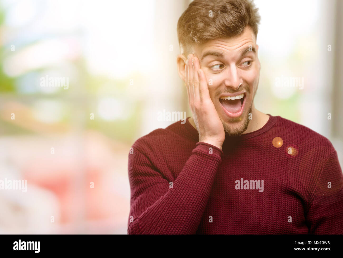 Handsome young man so happy and confident showing a big smile surprised ...
