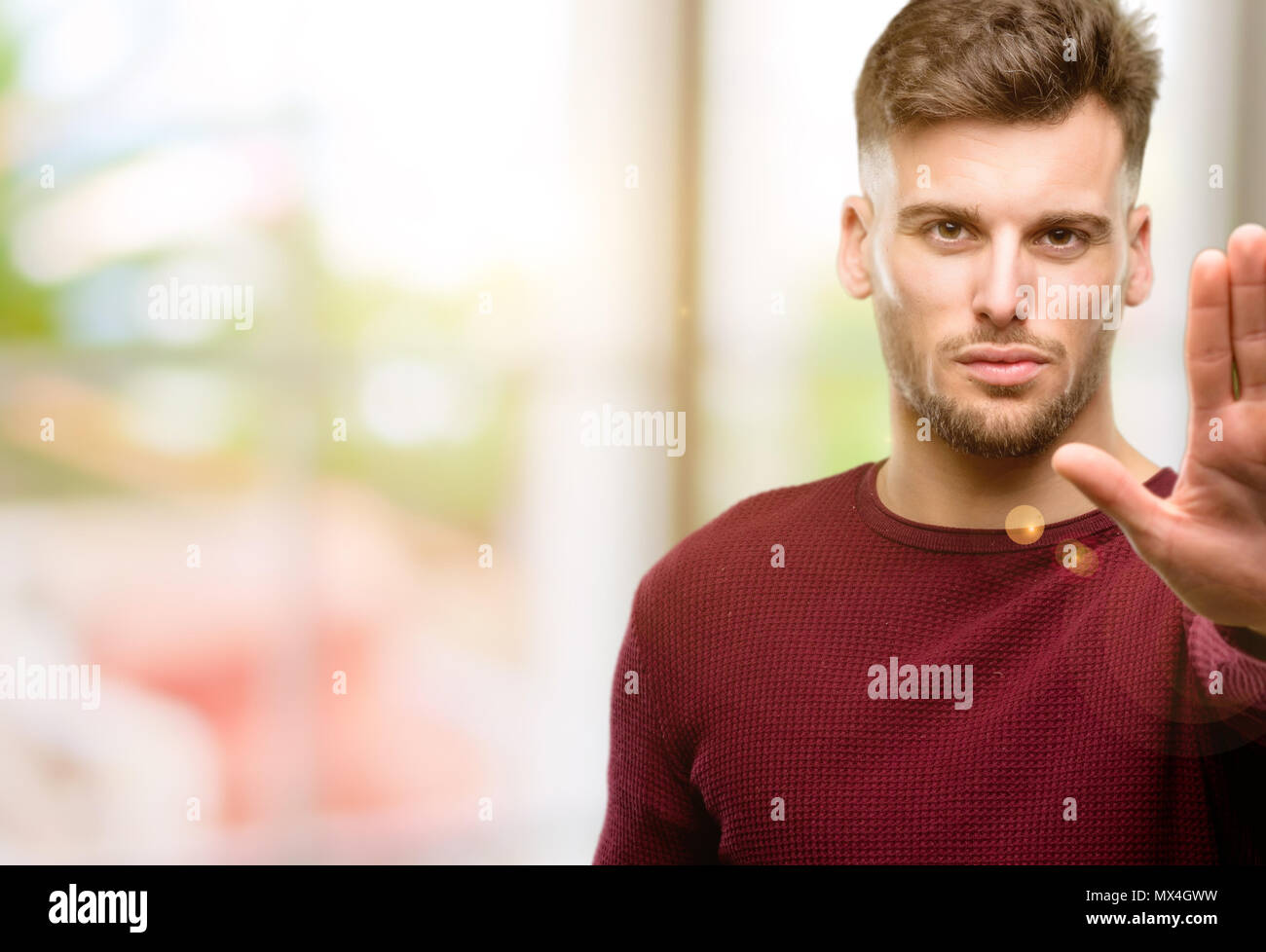 Handsome young man annoyed with bad attitude making stop sign with hand ...