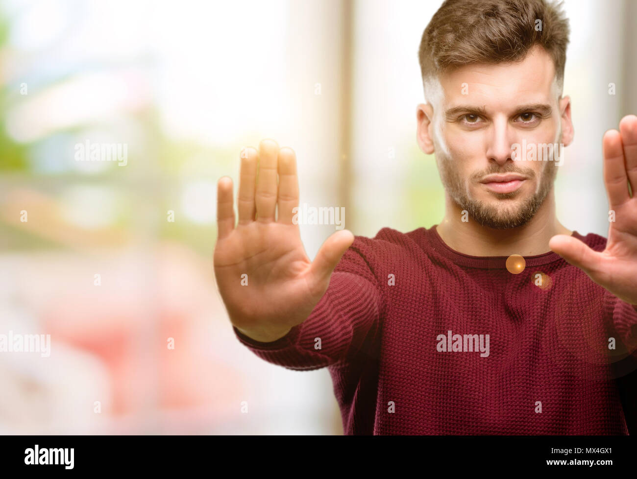 Handsome young man annoyed with bad attitude making stop sign with hand ...