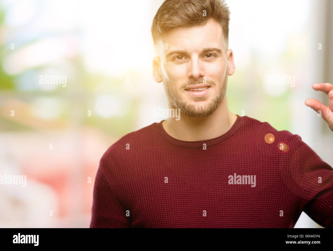 Handsome young man holding something very tiny, size concept Stock ...