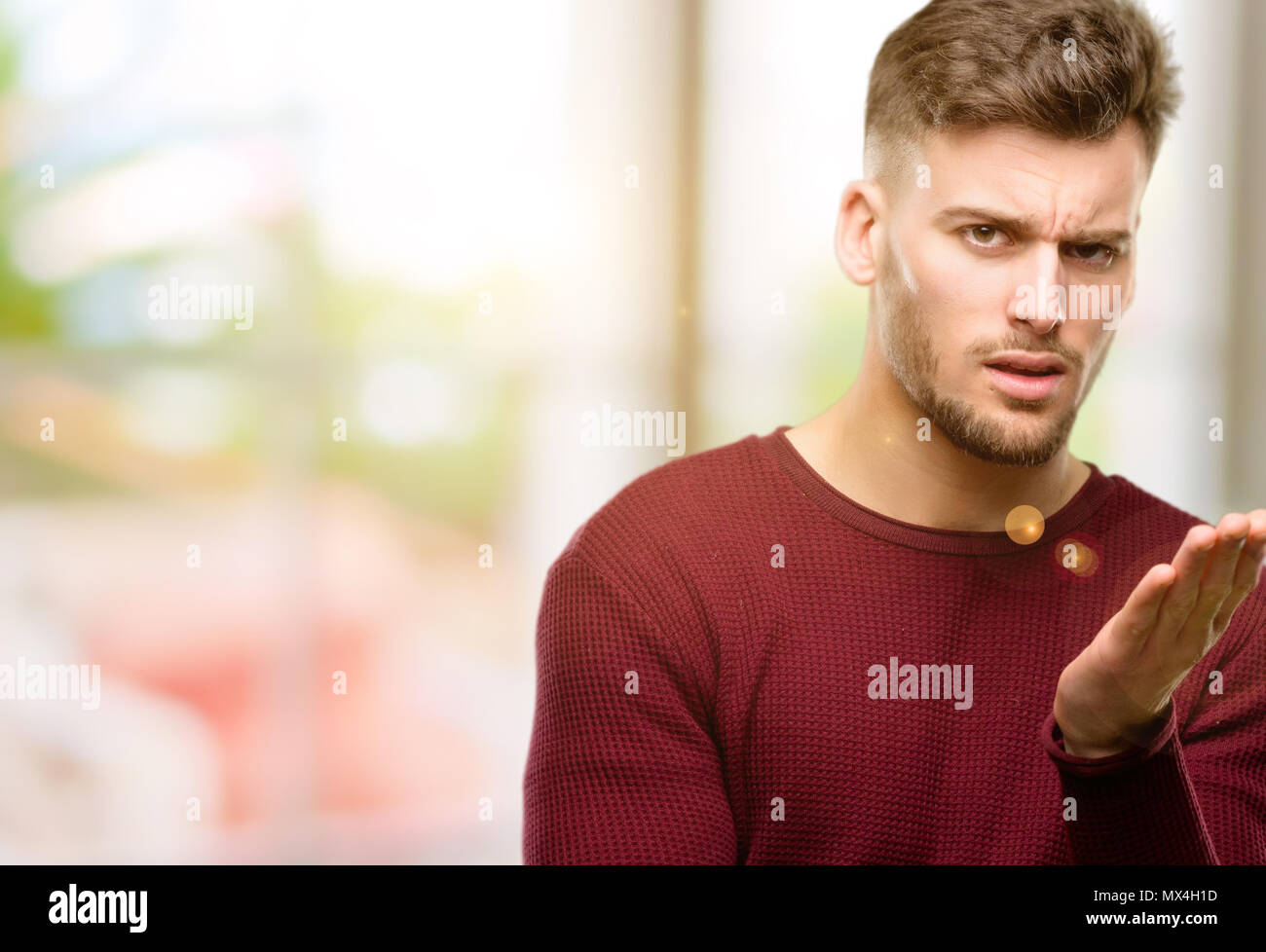 Handsome young man irritated and angry expressing negative emotion ...